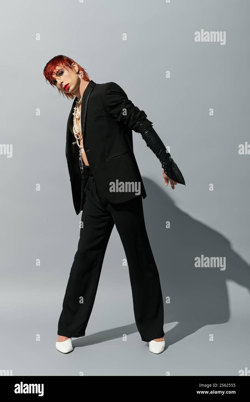 A young man poses confidently in a stylish outfit, demonstrating ...