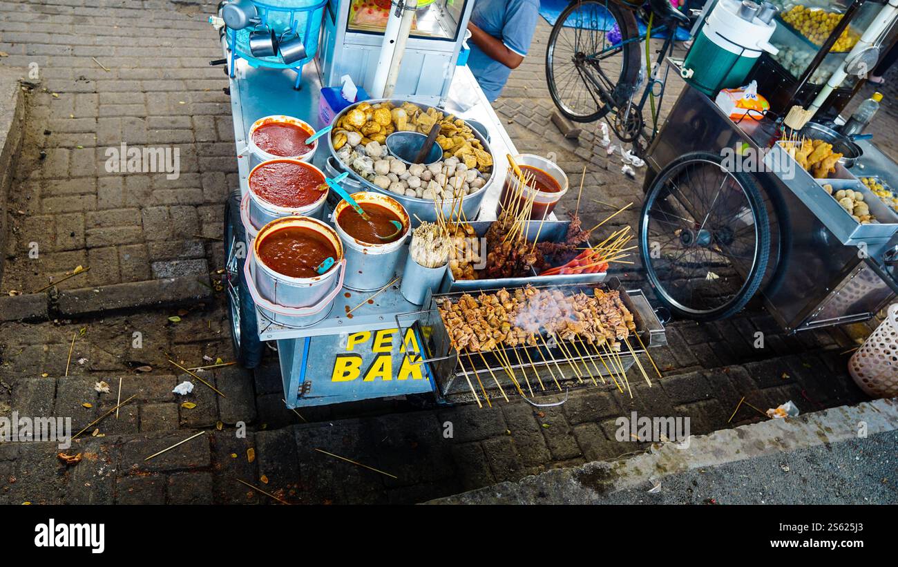 Vibrant street food vendor displaying grilled skewers, various sauces ...