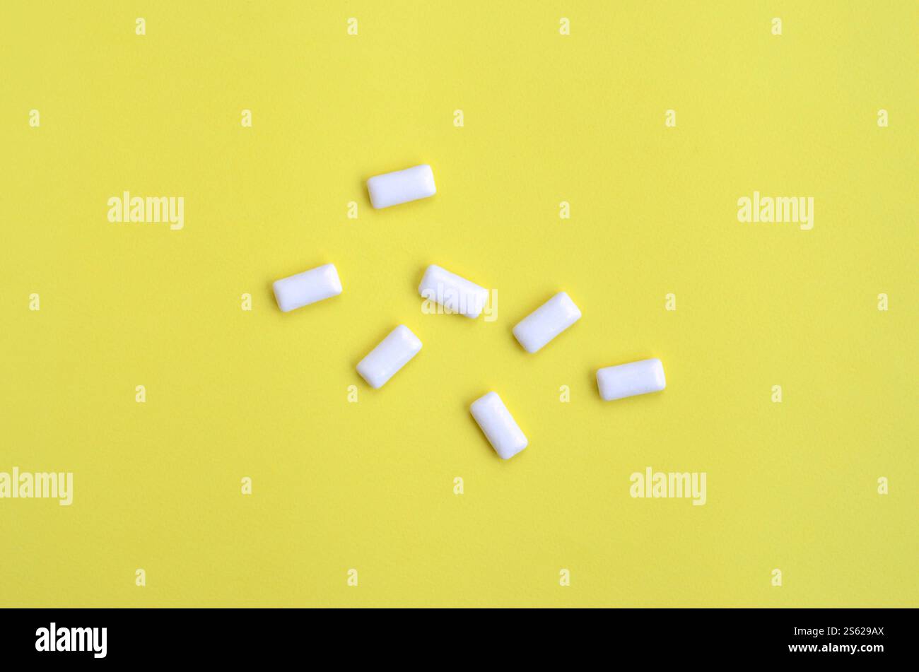 A few chewing gums lie on texture background of fashion pastel yellow ...