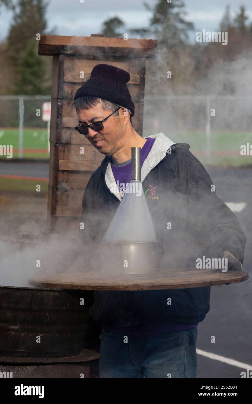 Alex Harui tends to a hot water pot for steaming sweet rice at the ...