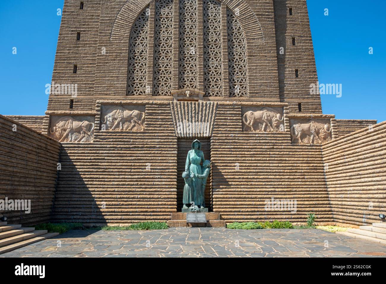 Voortrekker woman and children statue at Monument facade against blue ...