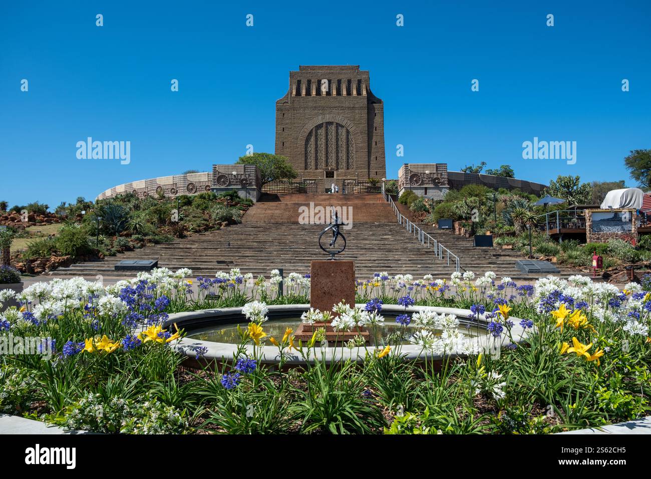 Voortrekker Monument and water fountain with flowers against blue sky ...