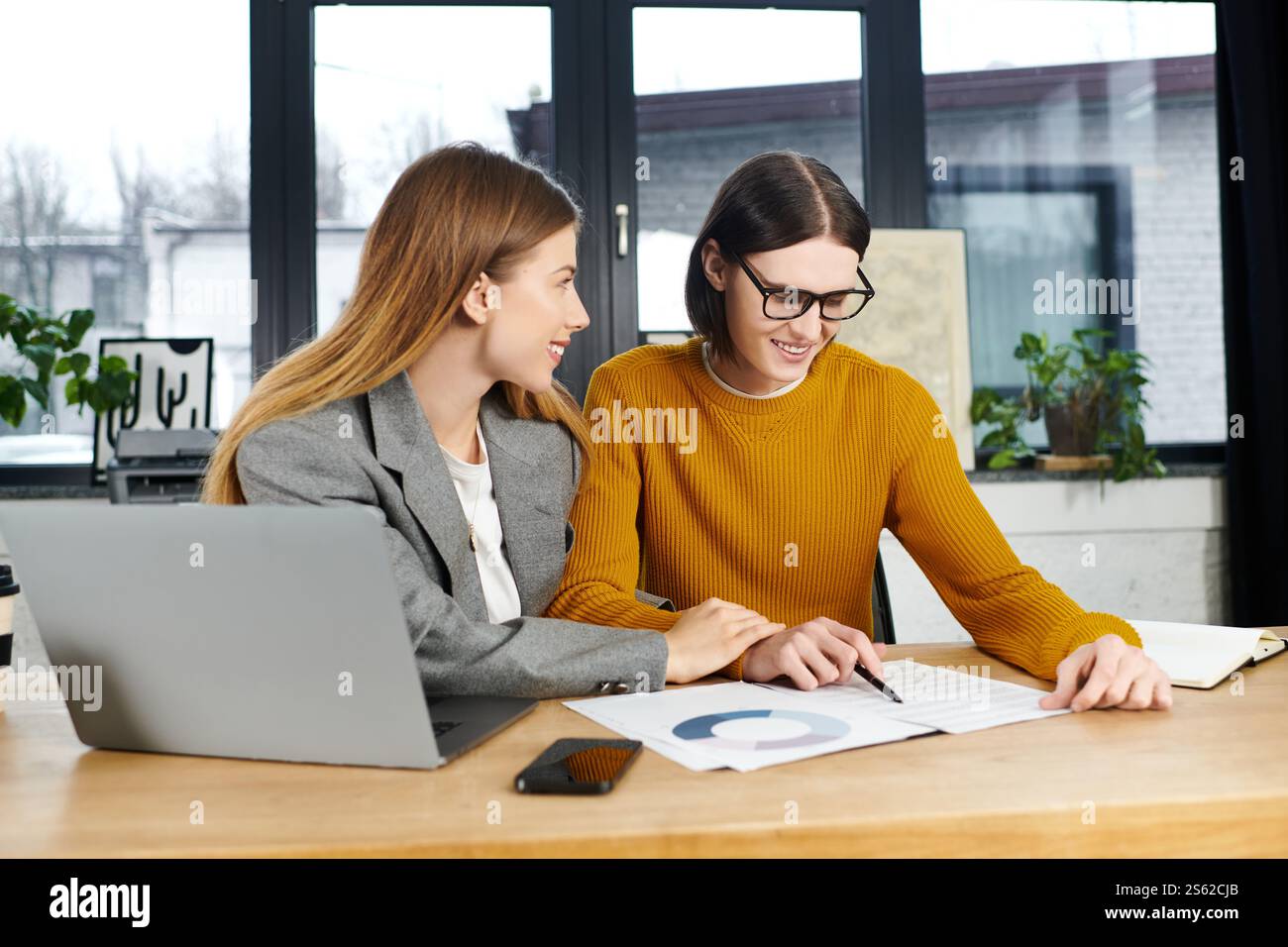 Two young people engage in a productive discussion while reviewing ...