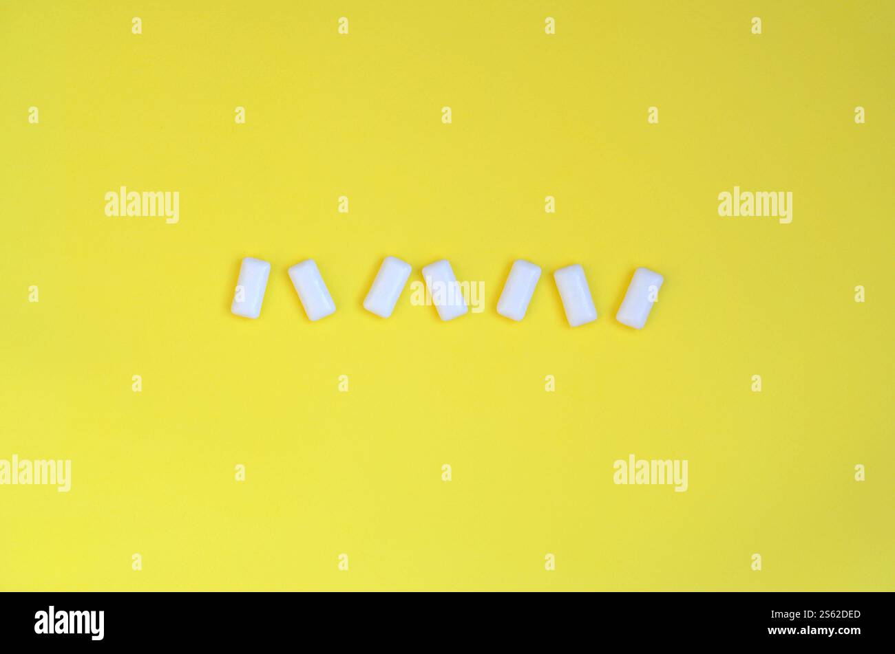 A few chewing gums lie on texture background of fashion pastel yellow ...