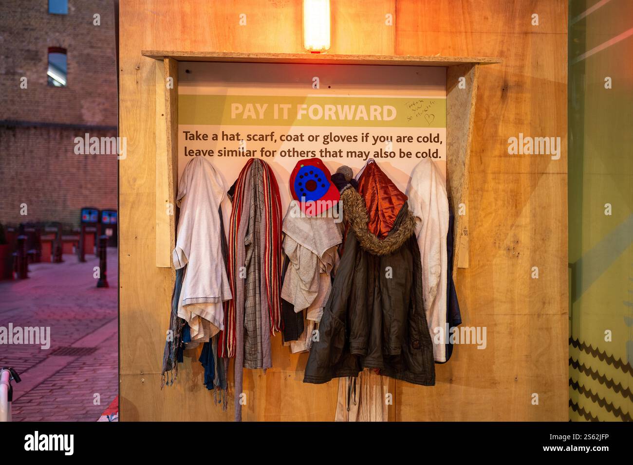 Clothes on rack at side of roadway in London for people who may be cold ...