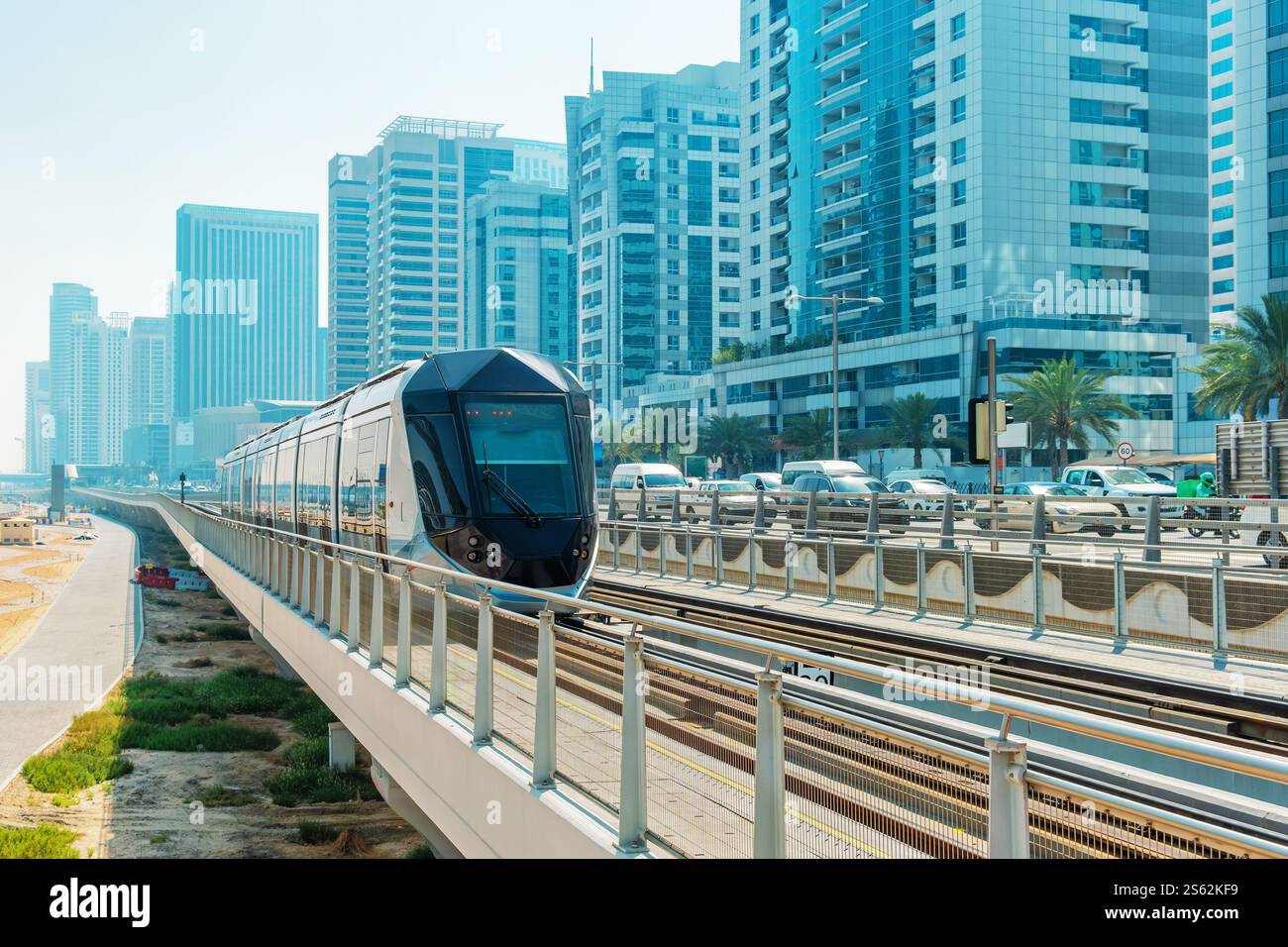 Dubai tram on elevated track passing through modern skyscrapers and ...