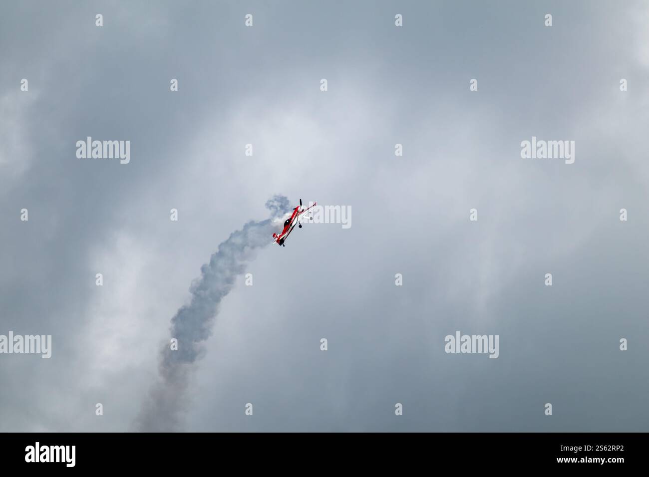 A red plane Su-31 flying high in the clouds during an airshow Stock ...
