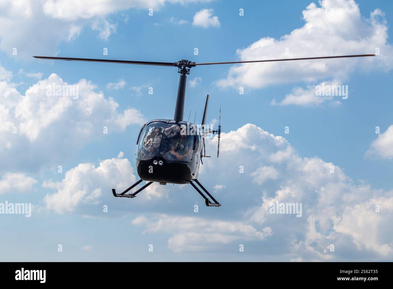 Shiny black helicopter hovering in cloudy sky background Stock Photo ...