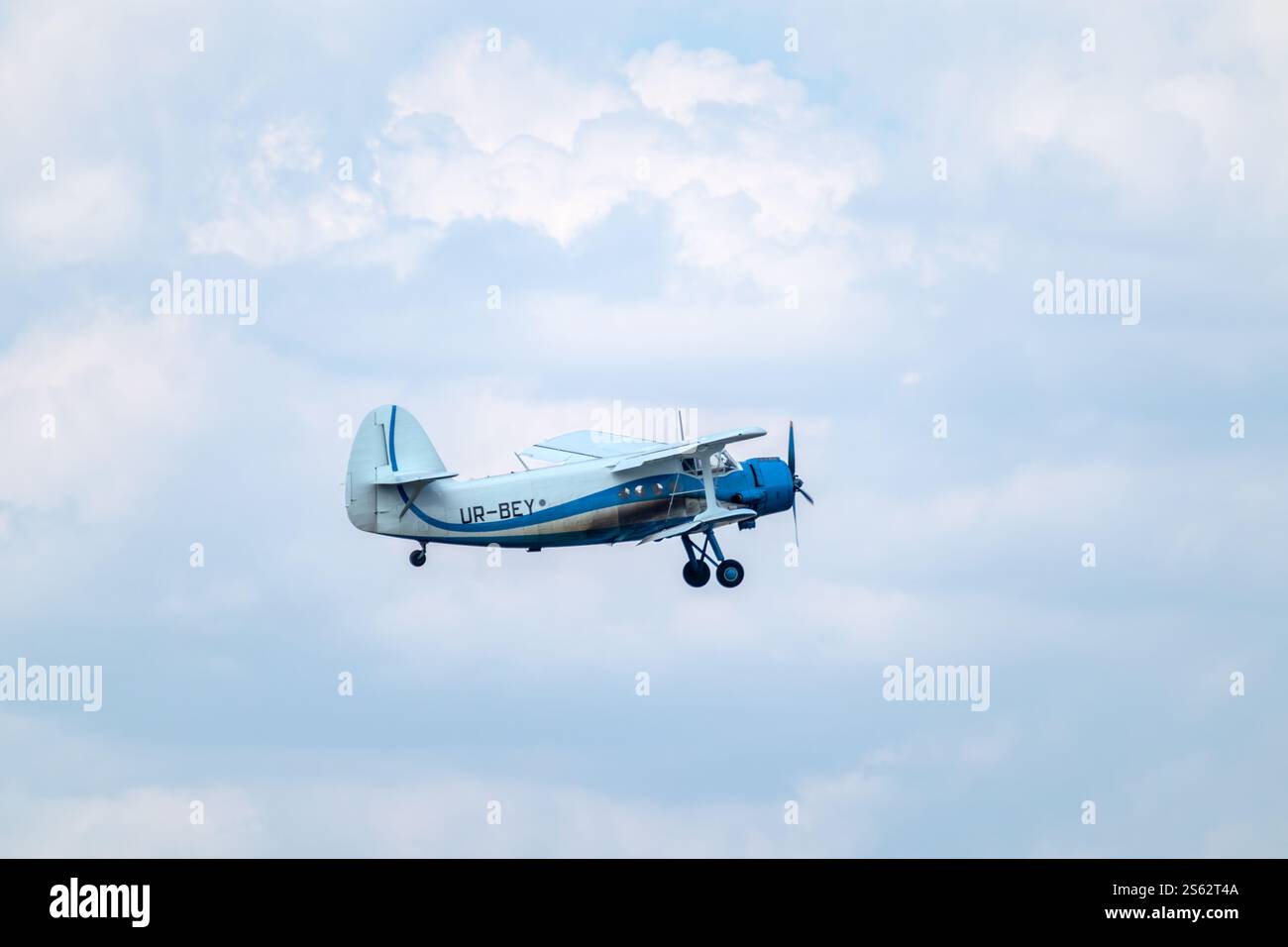 Antonov An-2 biplane passenger aircraft flying in blue sky with scenic ...