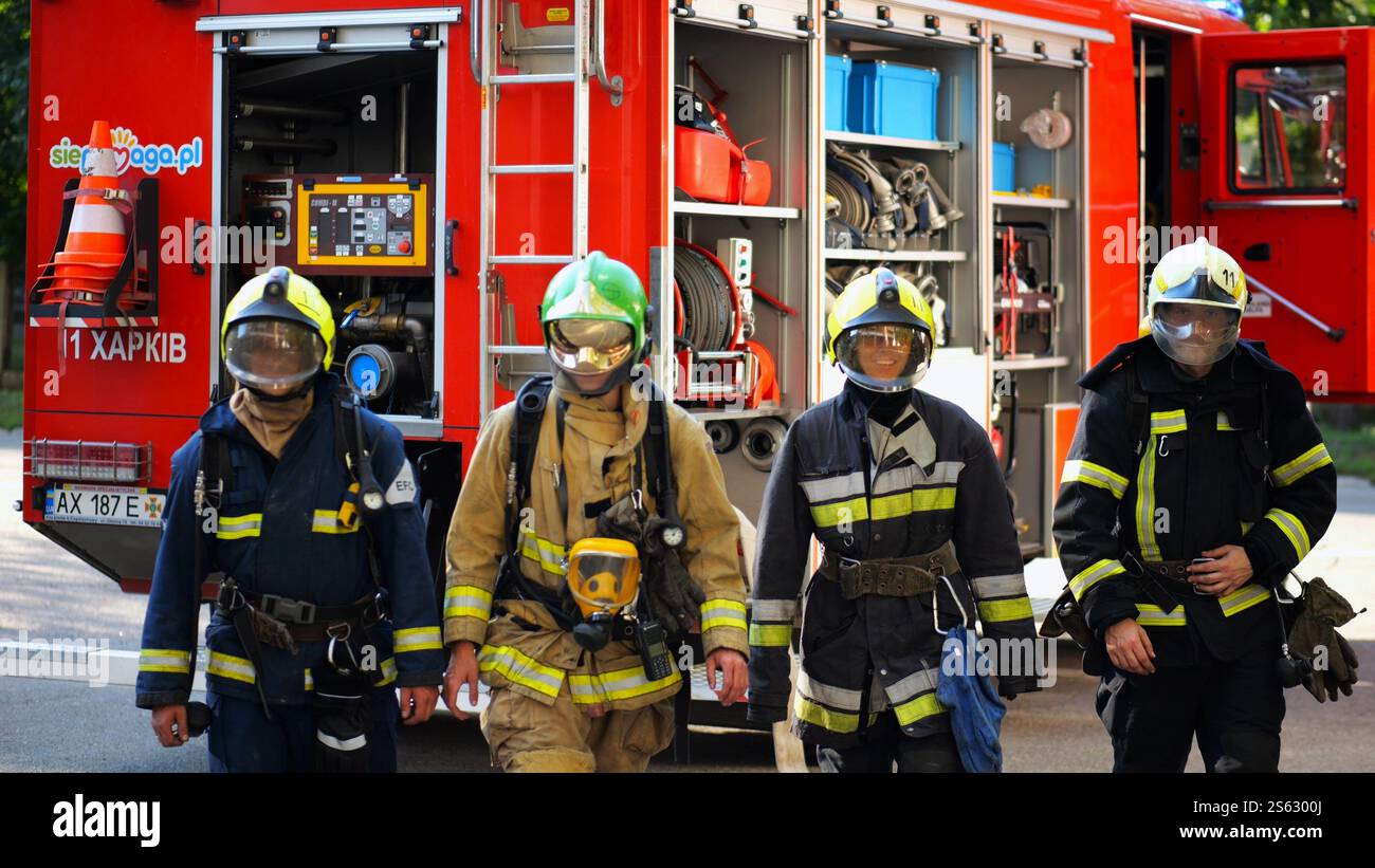Portrait of male and female firefighters in helmets and protective ...