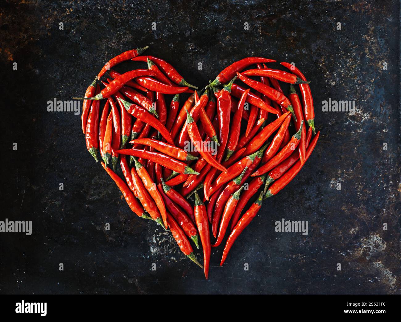 Red chili peppers in heart shape, for valentine's day on old black ...