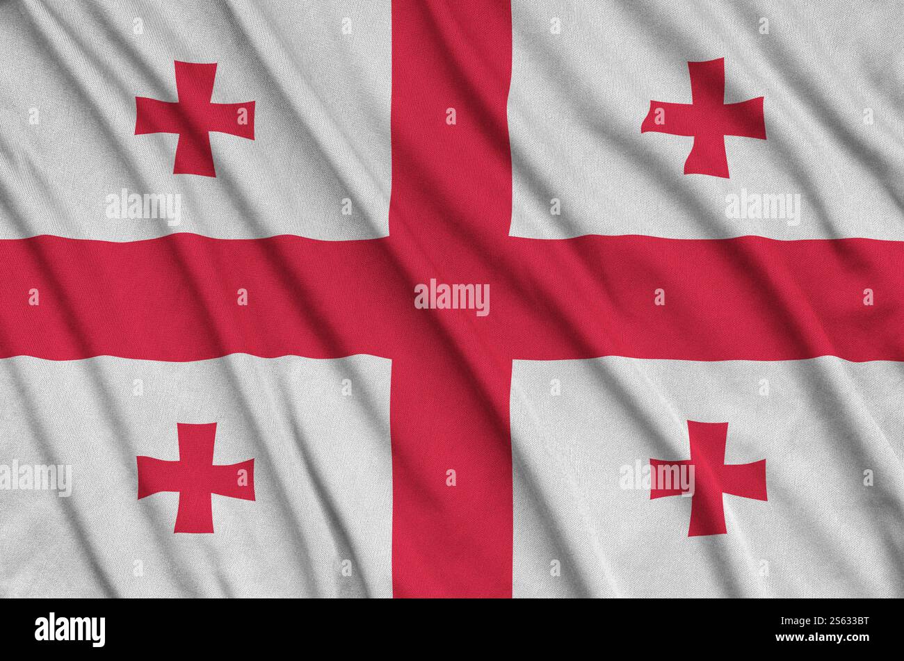 Georgia flag is depicted on a sports cloth fabric with many folds ...