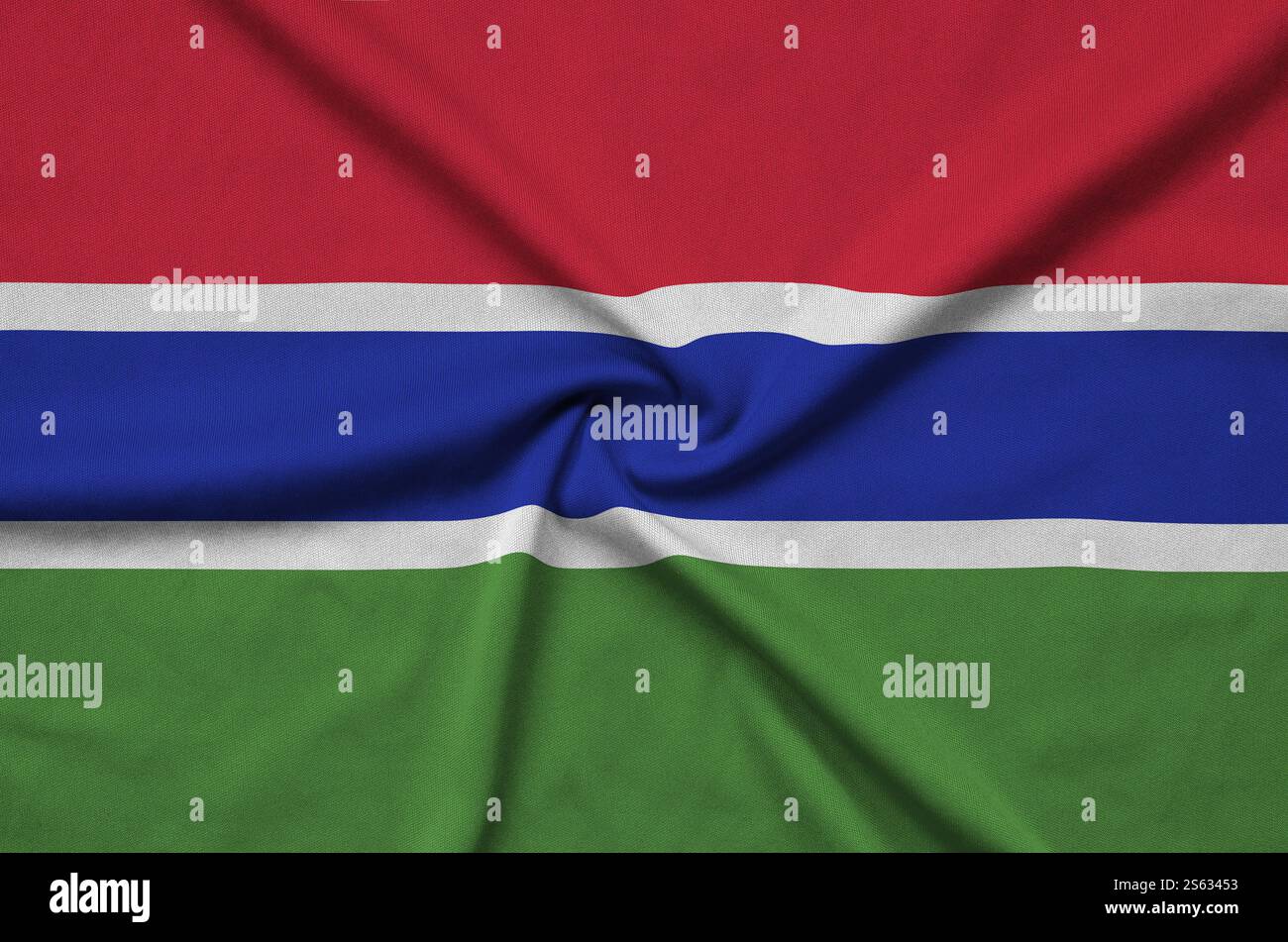 Gambia flag is depicted on a sports cloth fabric with many folds. Sport ...