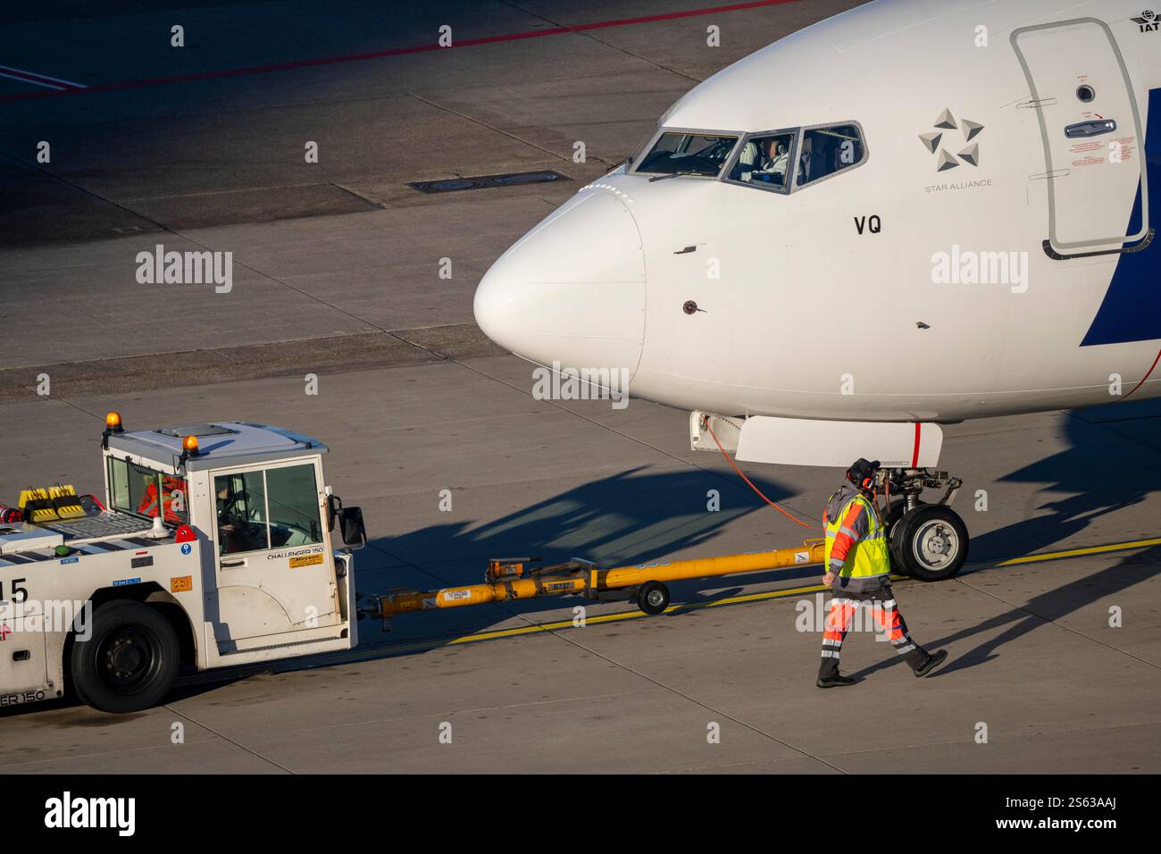 Aircraft being towed away from the gate at the terminal, ground crew ...