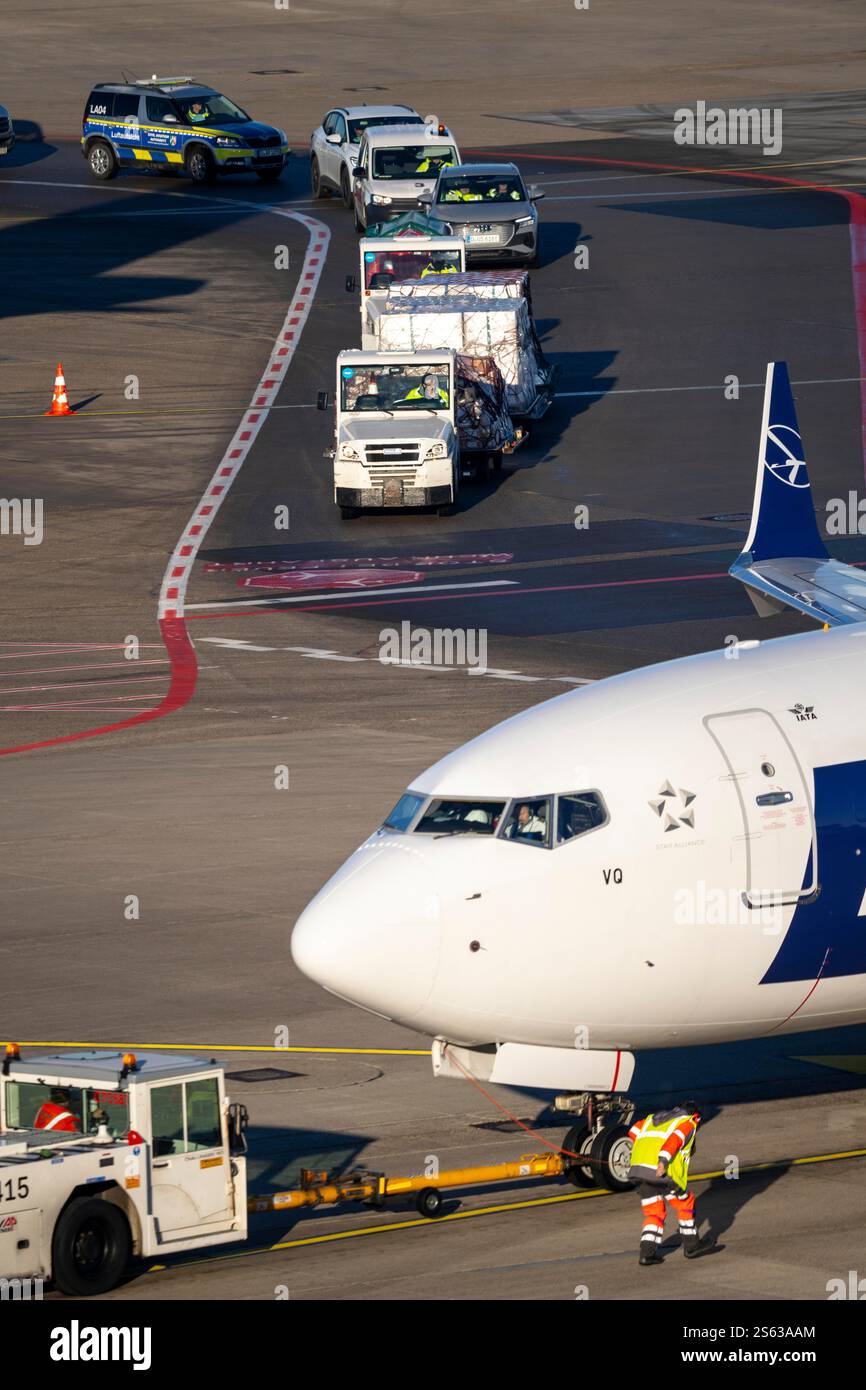 Aircraft being towed away from the gate at the terminal, ground crew ...