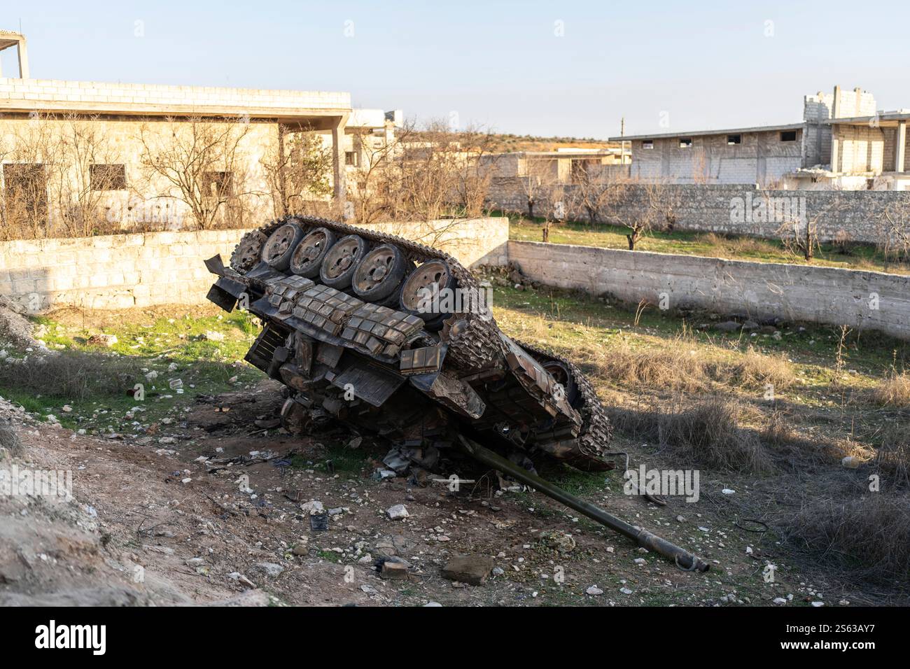 A damaged tank that belonged to the Assad regime lies in a ditch, on ...