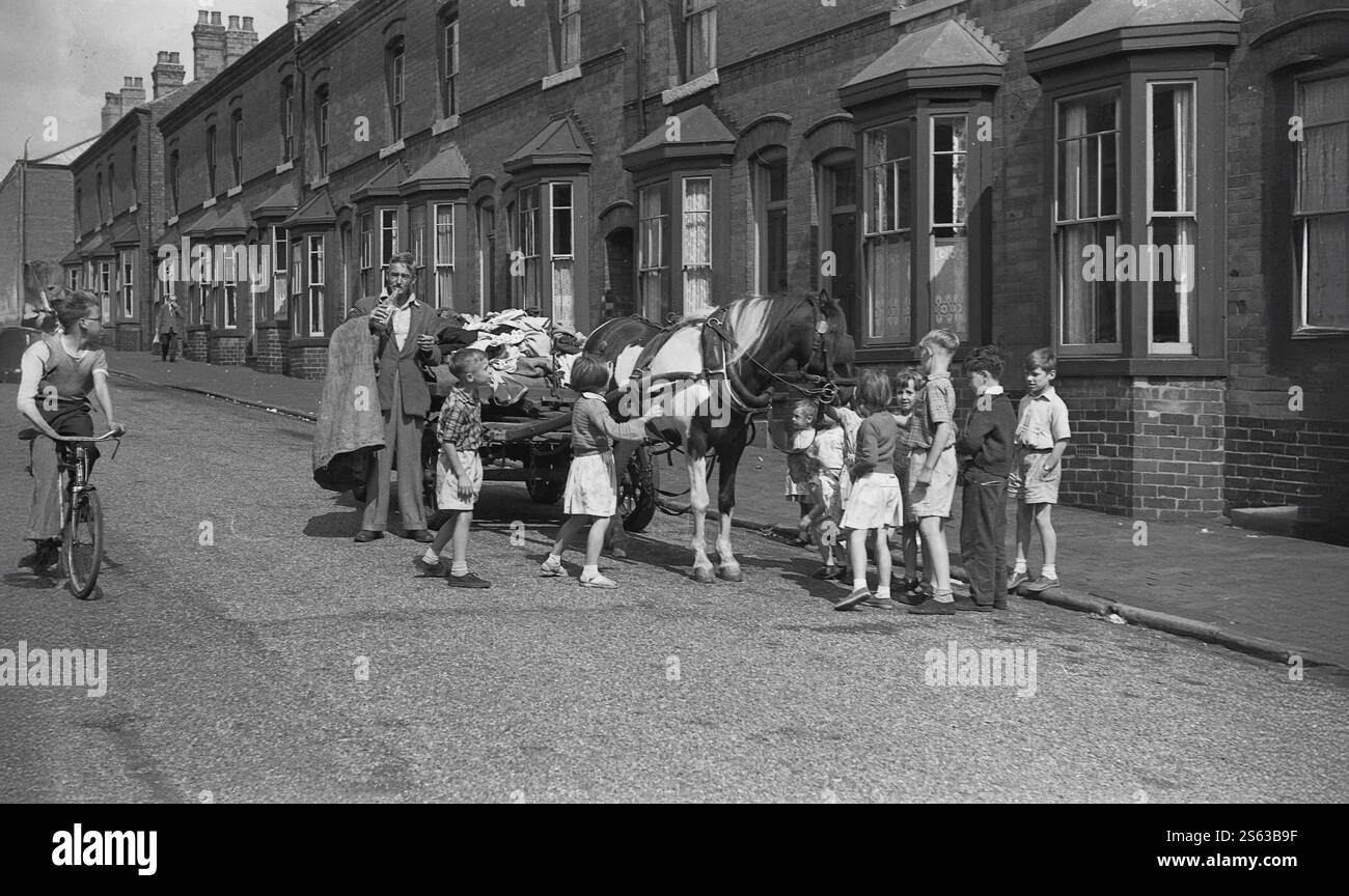 Rag and Bone man with horse and cart surrounded by children in street ...