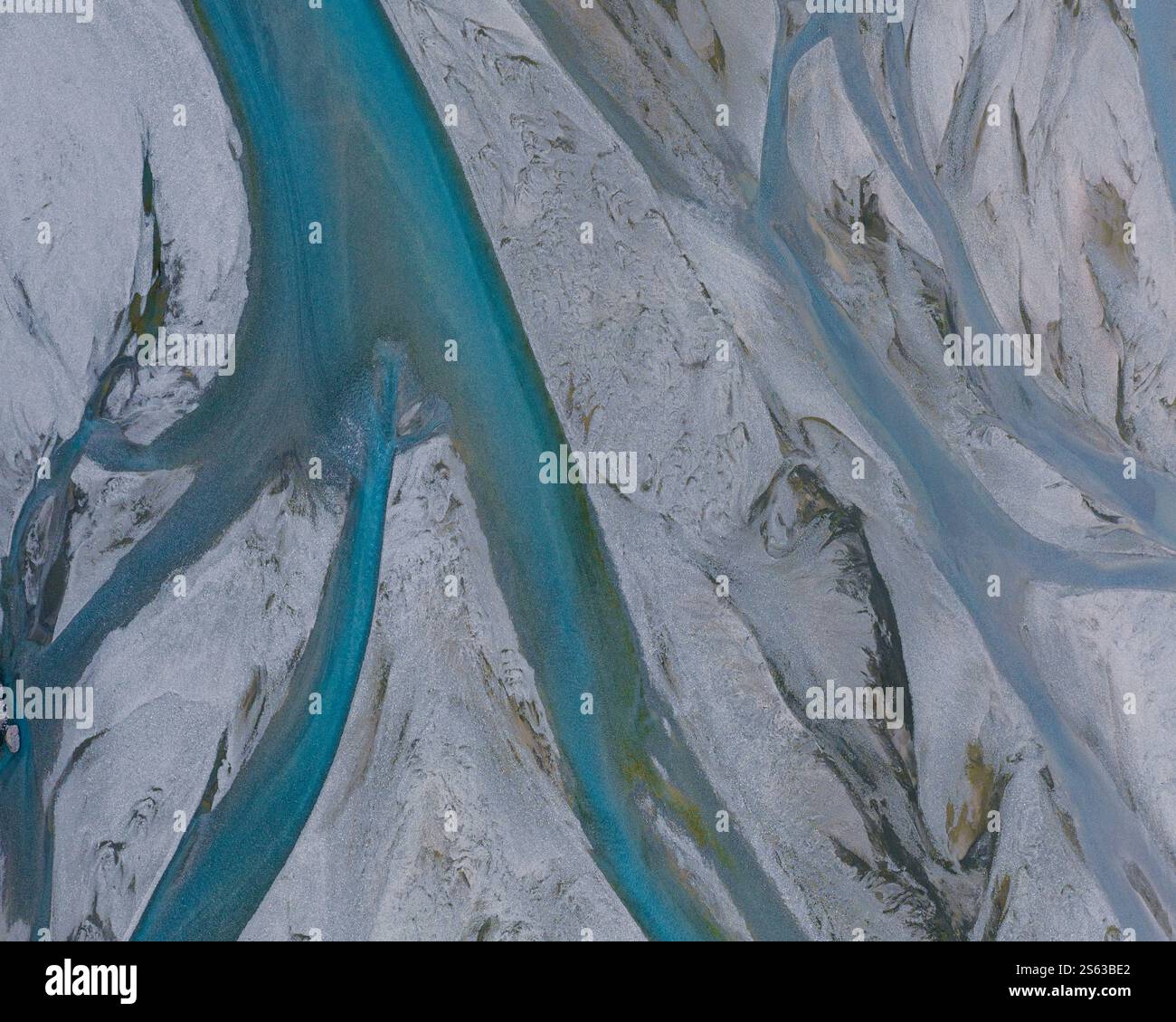 Aerial view of vibrant braided glacial rivers winding through ...