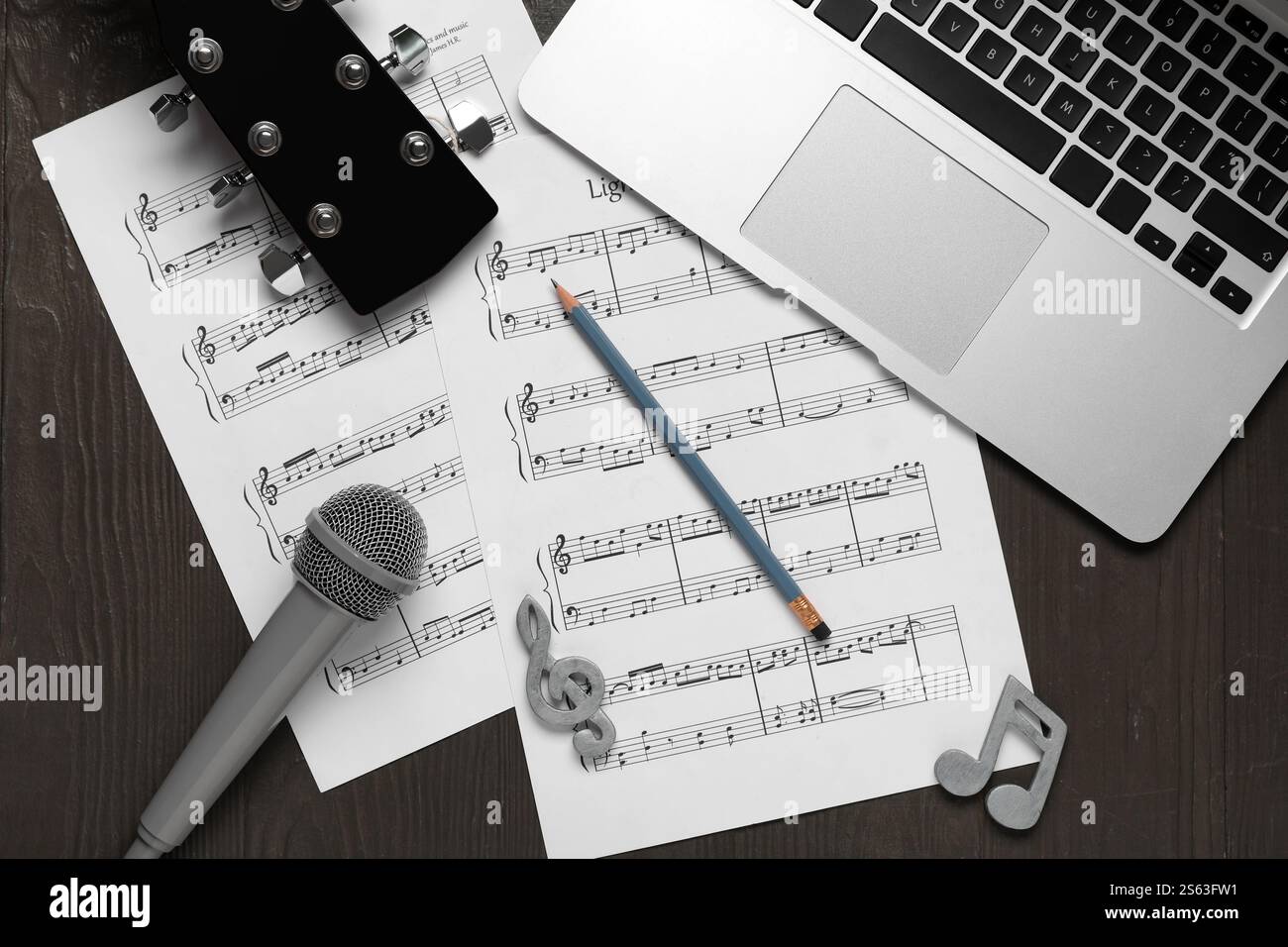 Music sheets with laptop, microphone and guitar on wooden background ...