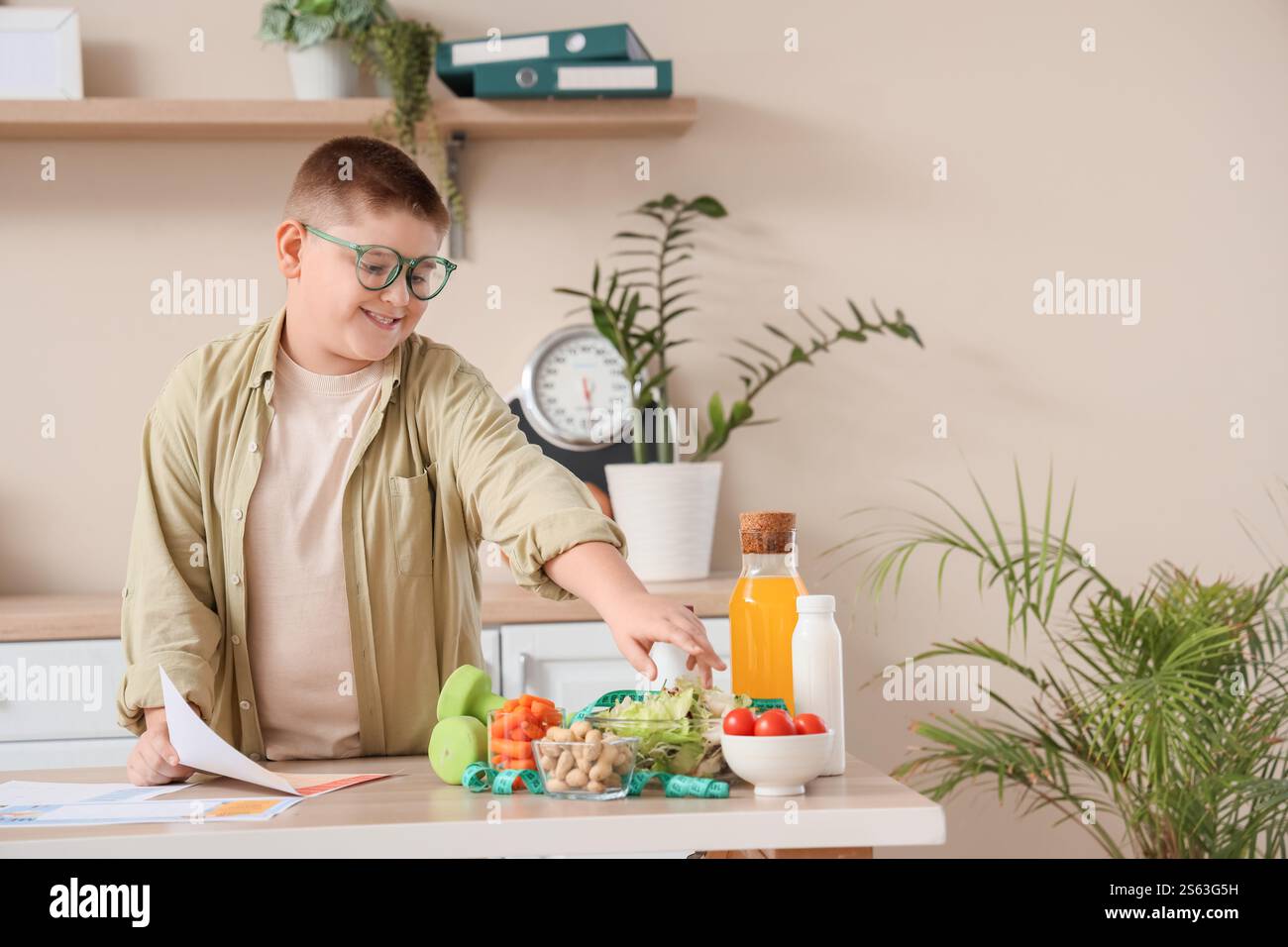 Overweight boy with meal plan and healthy food at nutritionist's office ...
