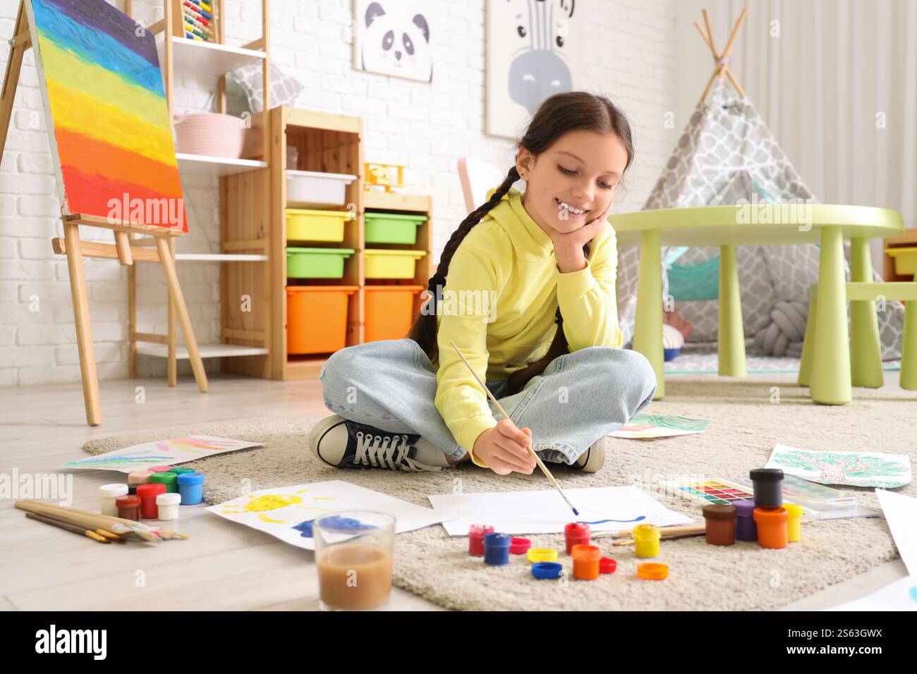 Cute girl painting on carpet at home Stock Photo - Alamy
