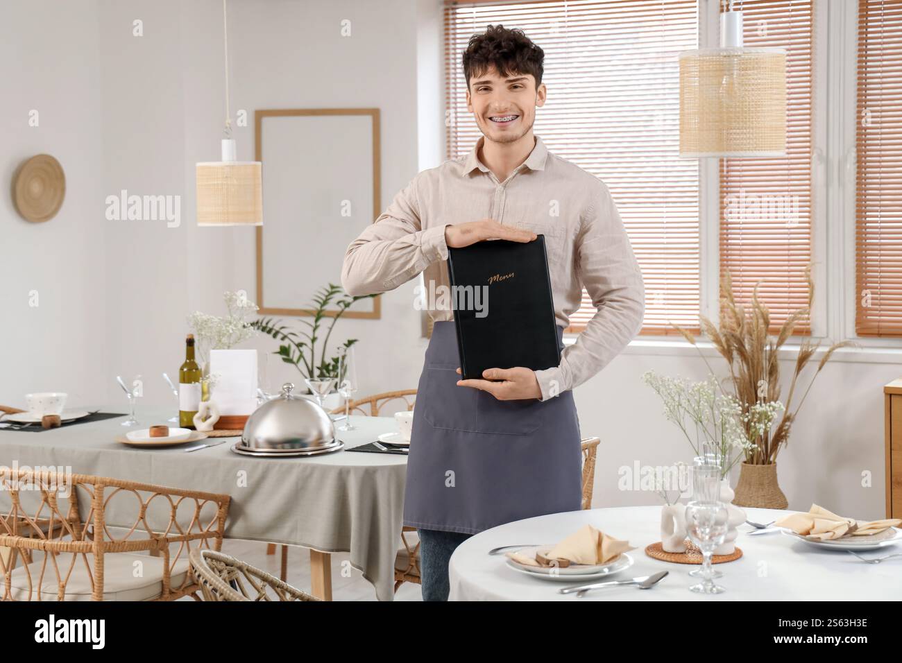 Male waiter with menu in restaurant Stock Photo - Alamy