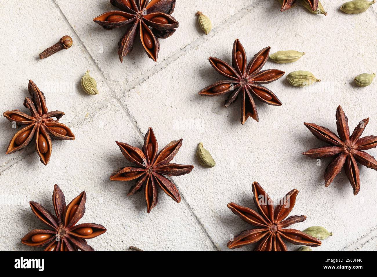 Anise stars with seeds and clove on white tile background Stock Photo ...