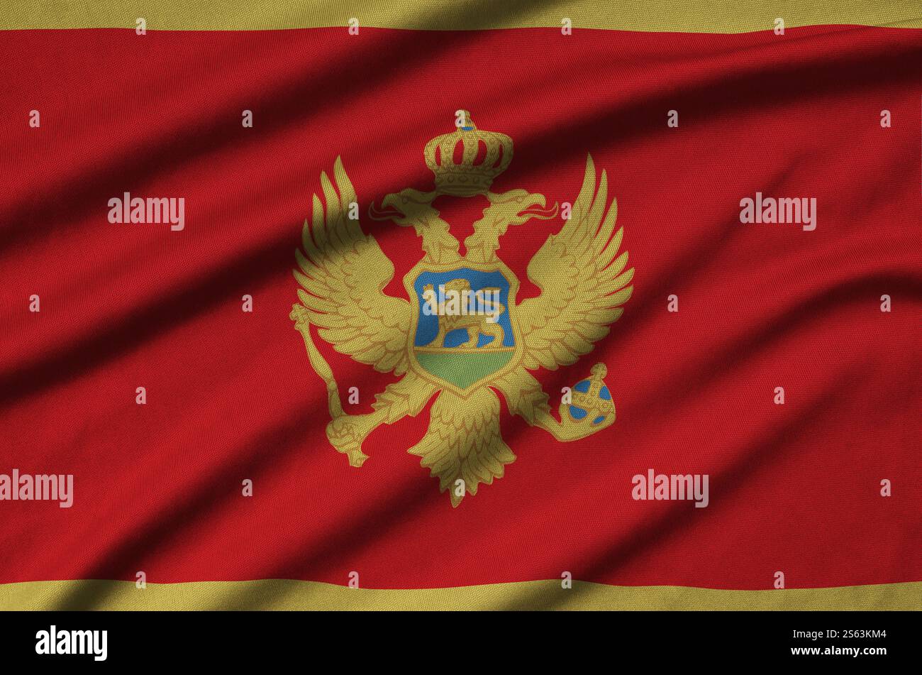 Montenegro flag is depicted on a sports cloth fabric with many folds ...