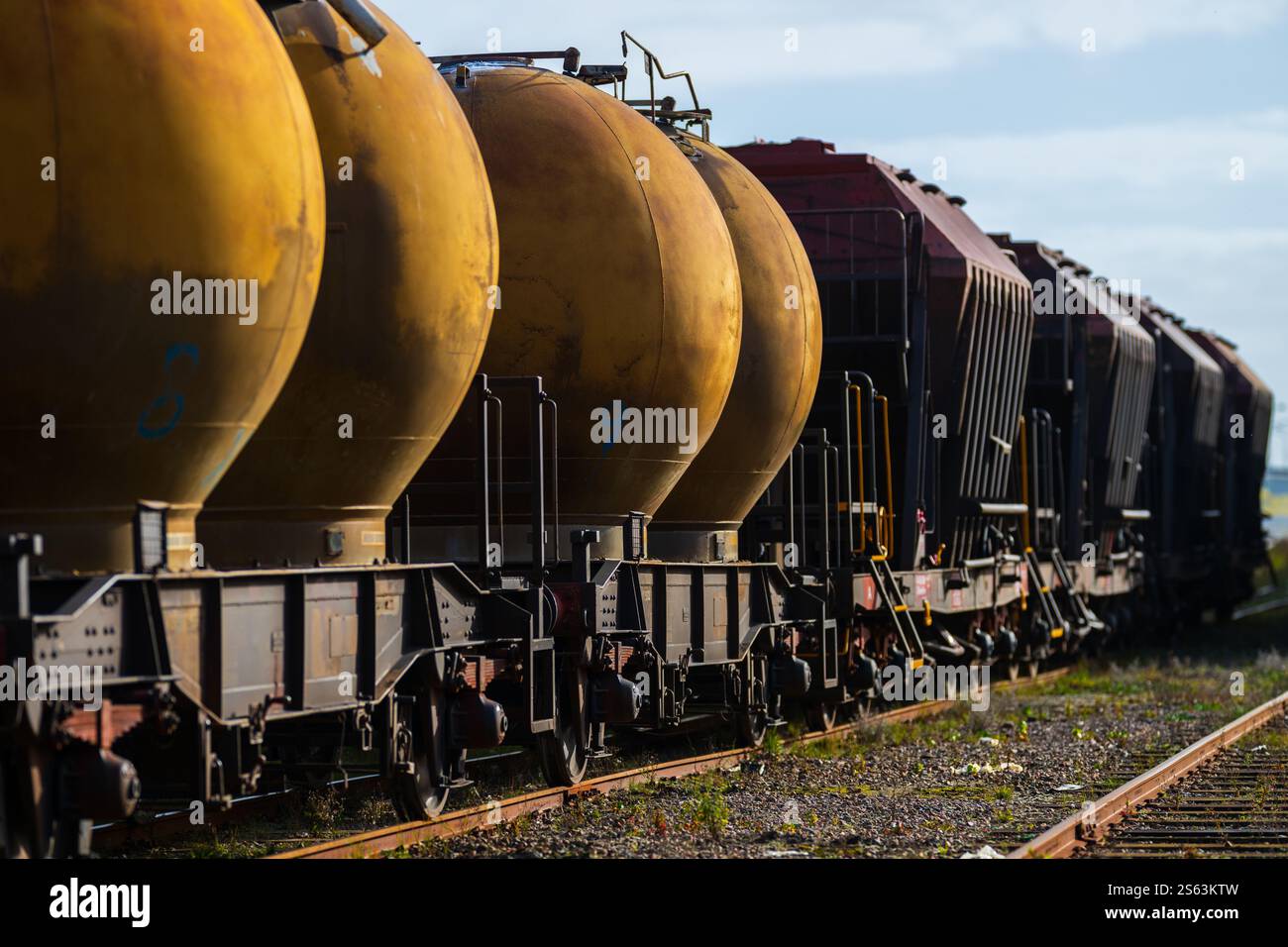 Freight train transporting tanks through an industrial area Stock Photo ...