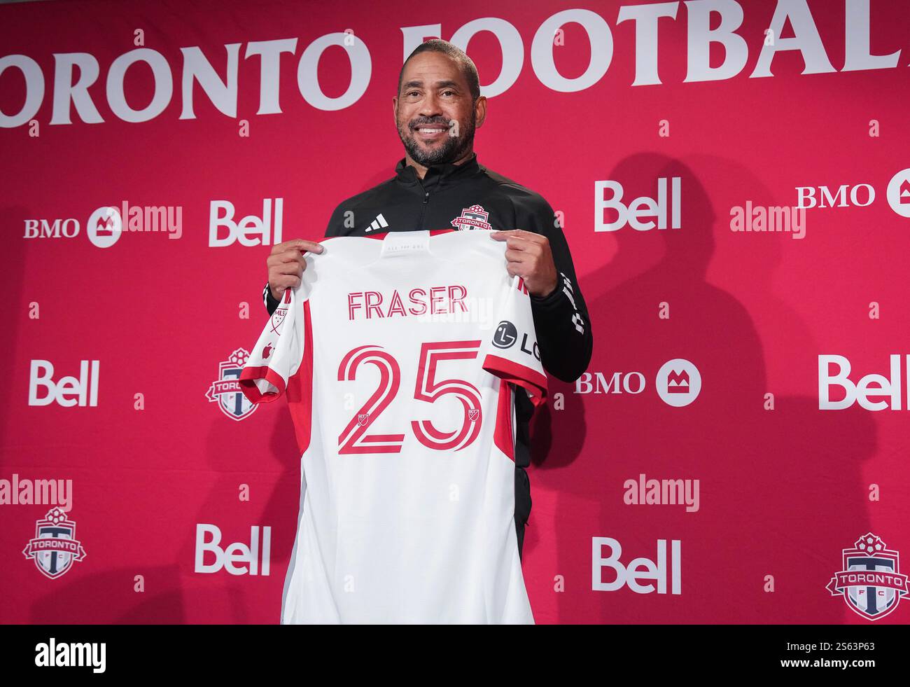 Robin Fraser, Toronto FC's new head coach, holds up a team jersey with ...