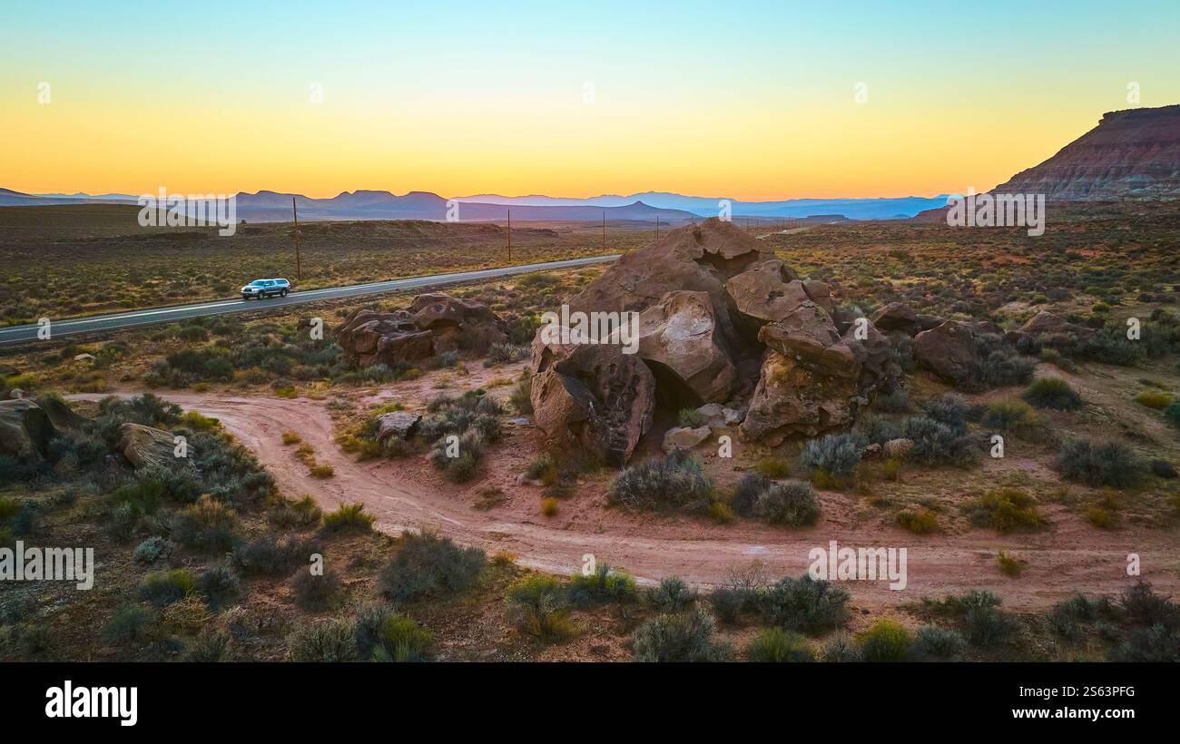 Aerial of Rugged Desert Landscape with Car at Sunset Stock Photo - Alamy