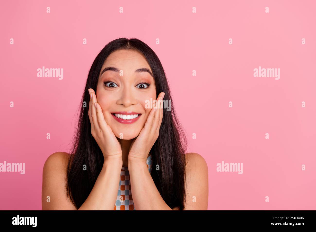 Joyful young Asian woman expressing surprise against pink background ...