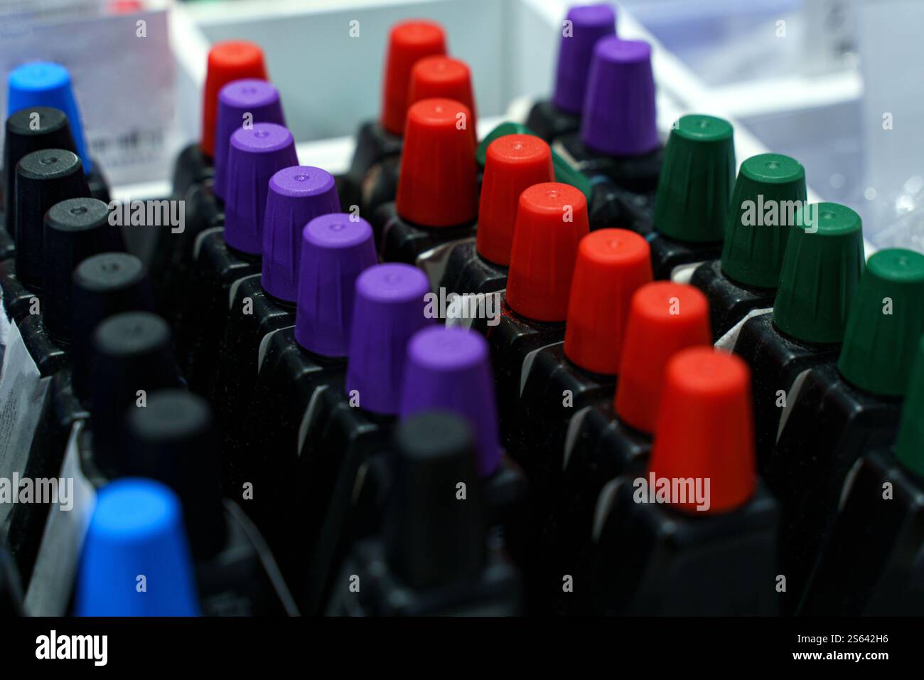 A variety of ink bottles are neatly organized on display, each with ...