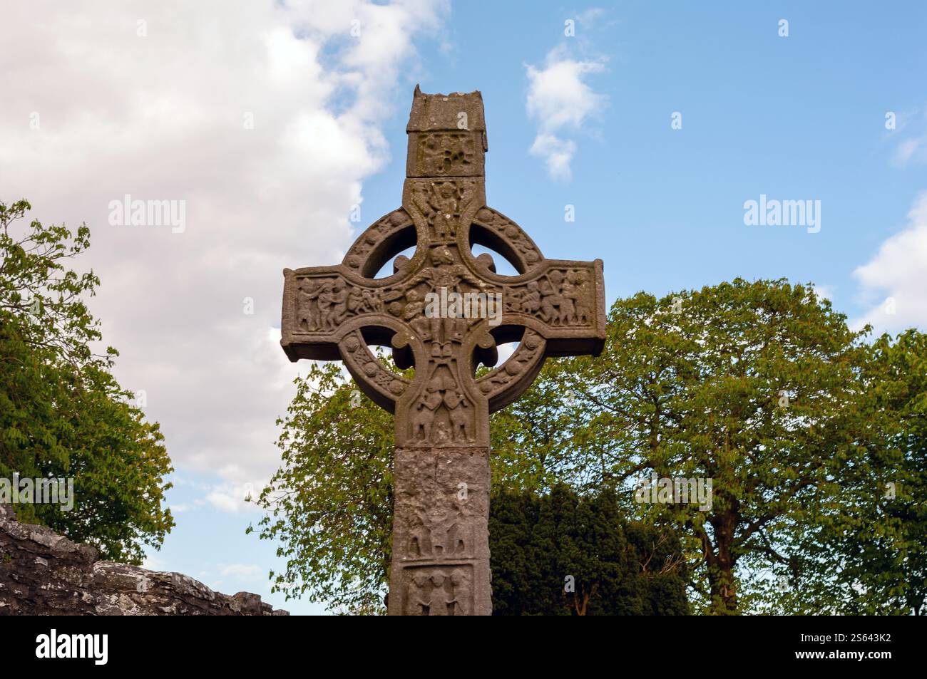 A large stone cross with a circle in the middle. The sky is blue and ...