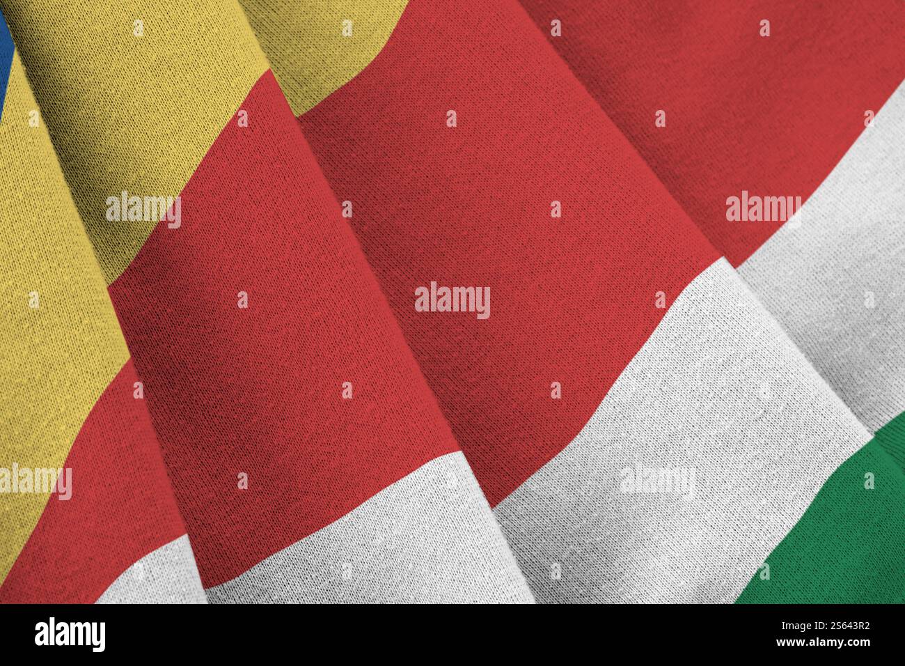 Seychelles flag with big folds waving close up under the studio light ...