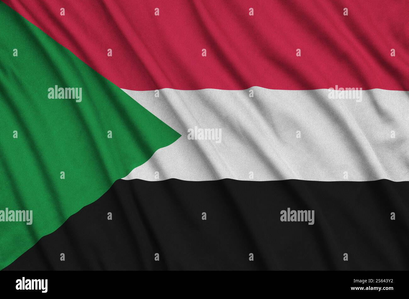 Sudan flag is depicted on a sports cloth fabric with many folds. Sport ...