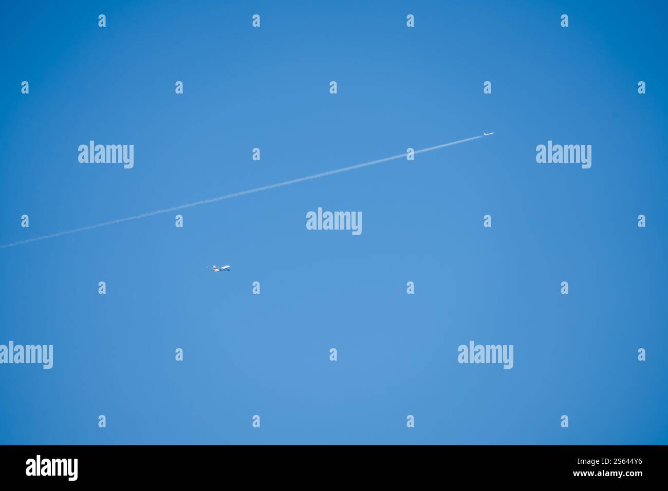 Airbus A380 and a twin engined jet liner aircraft in deep blue sky ...