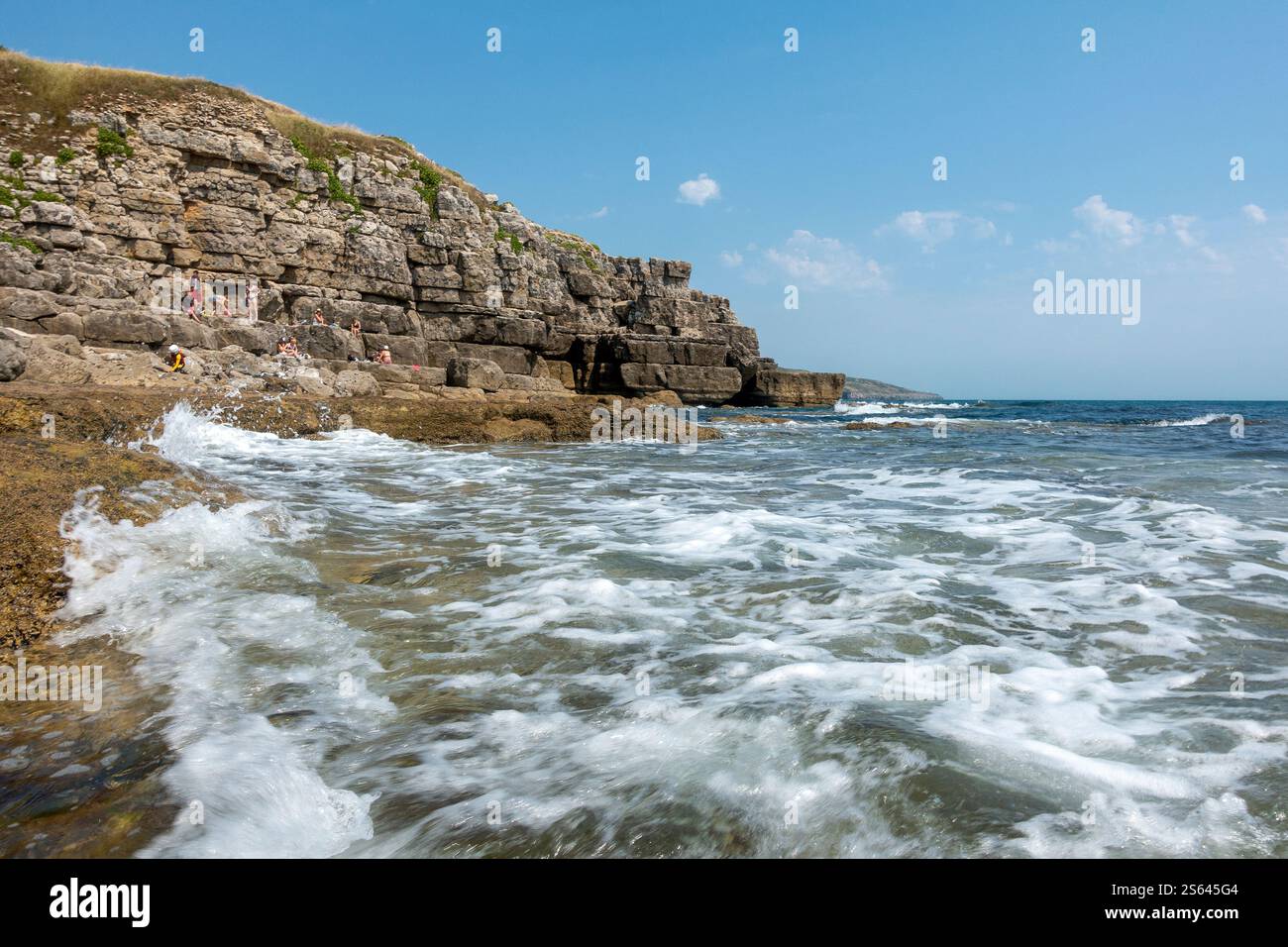 Visitors enjoy the beautiful rocky shoreline at Winspit Quarry while ...