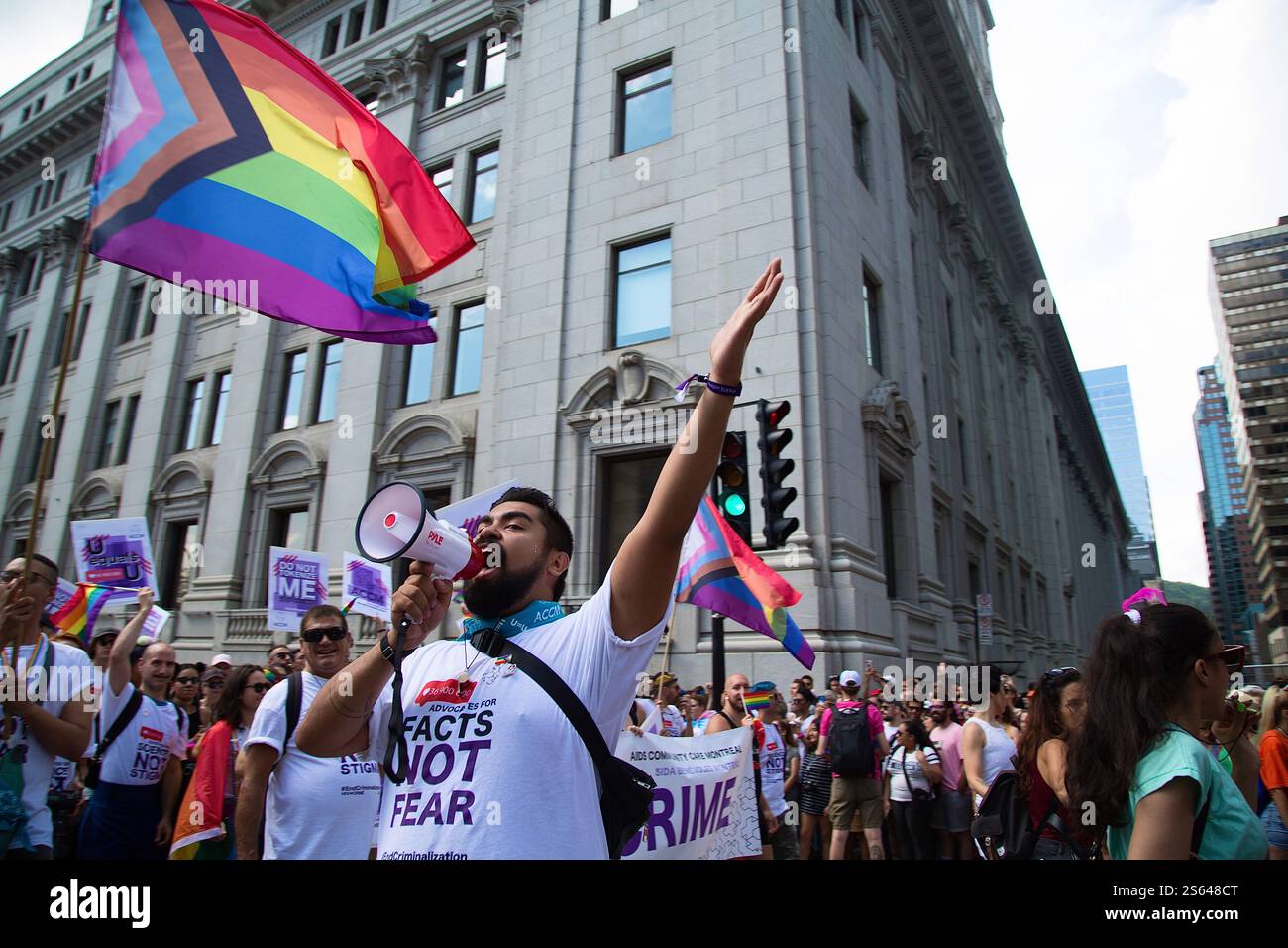 A passionate speaker with a megaphone rallies the crowd during a Pride ...