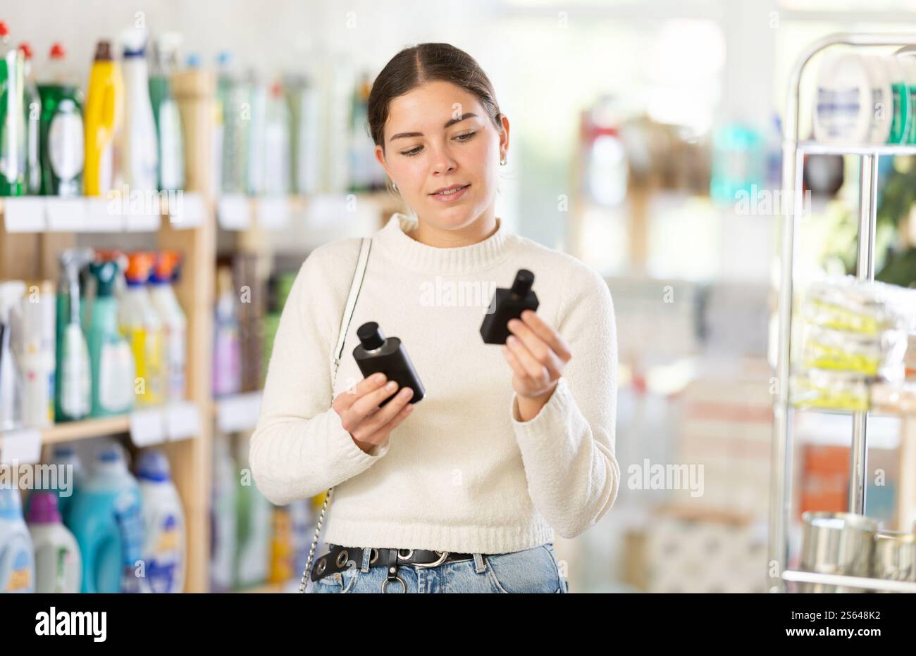 Young woman client sniffs fragrance of perfume, chooses scent spray ...