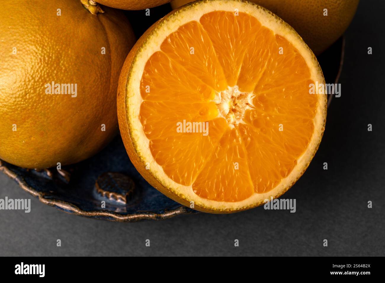 Ripe half of chocolate orange fruit on dark background without shadow ...
