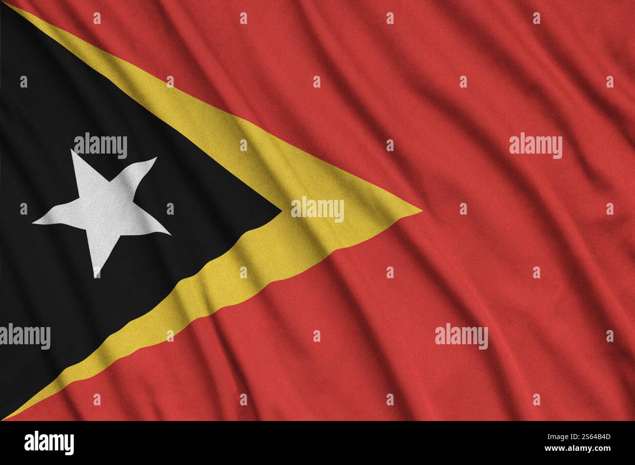 Timor Leste flag is depicted on a sports cloth fabric with many folds ...