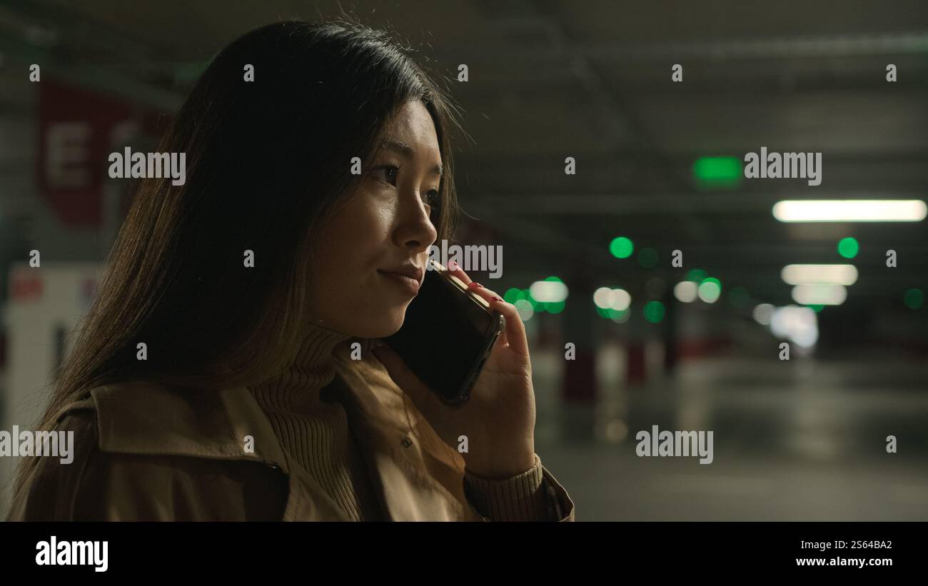 Worried upset Asian woman talk mobile phone in parking call worried ...