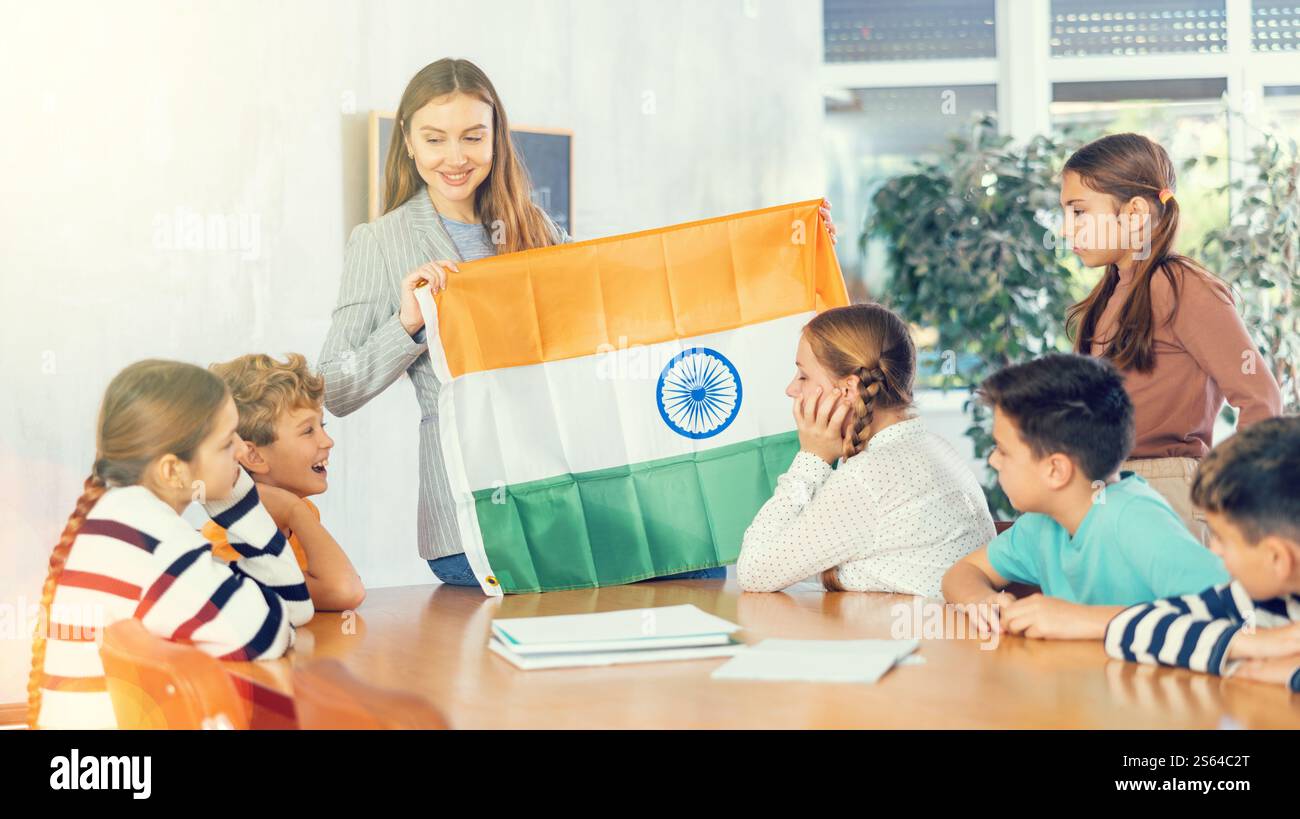 Female teacher working with students in school class, talking about ...