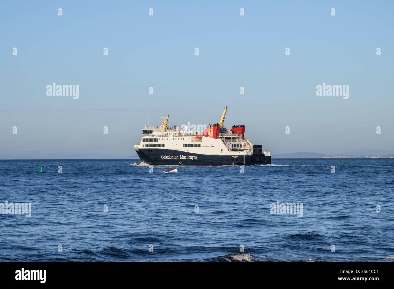 People in a rowing boat beside the Glen Sannox ferry departing from ...