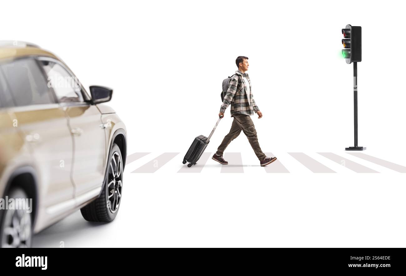 Full length profile shot of a student with a suitcase crossing a street ...