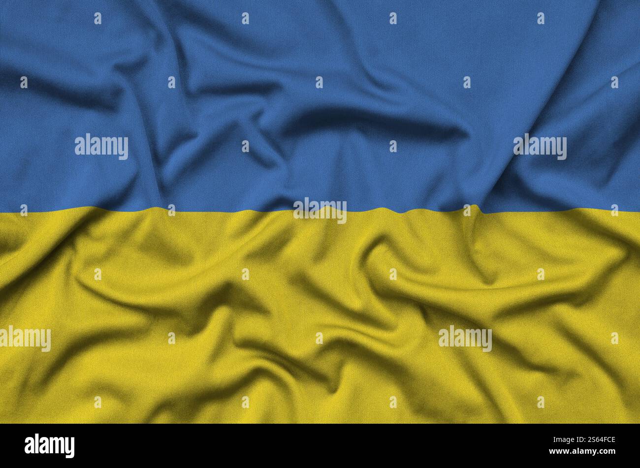 Ukraine flag is depicted on a sports cloth fabric with many folds ...