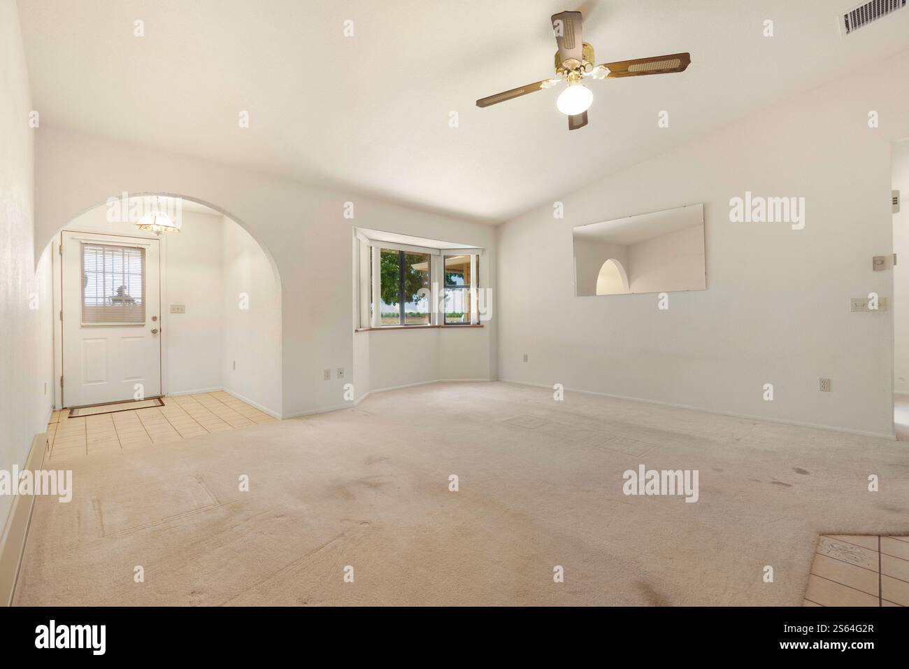 Light-filled living area features elegant wooden flooring and high ...
