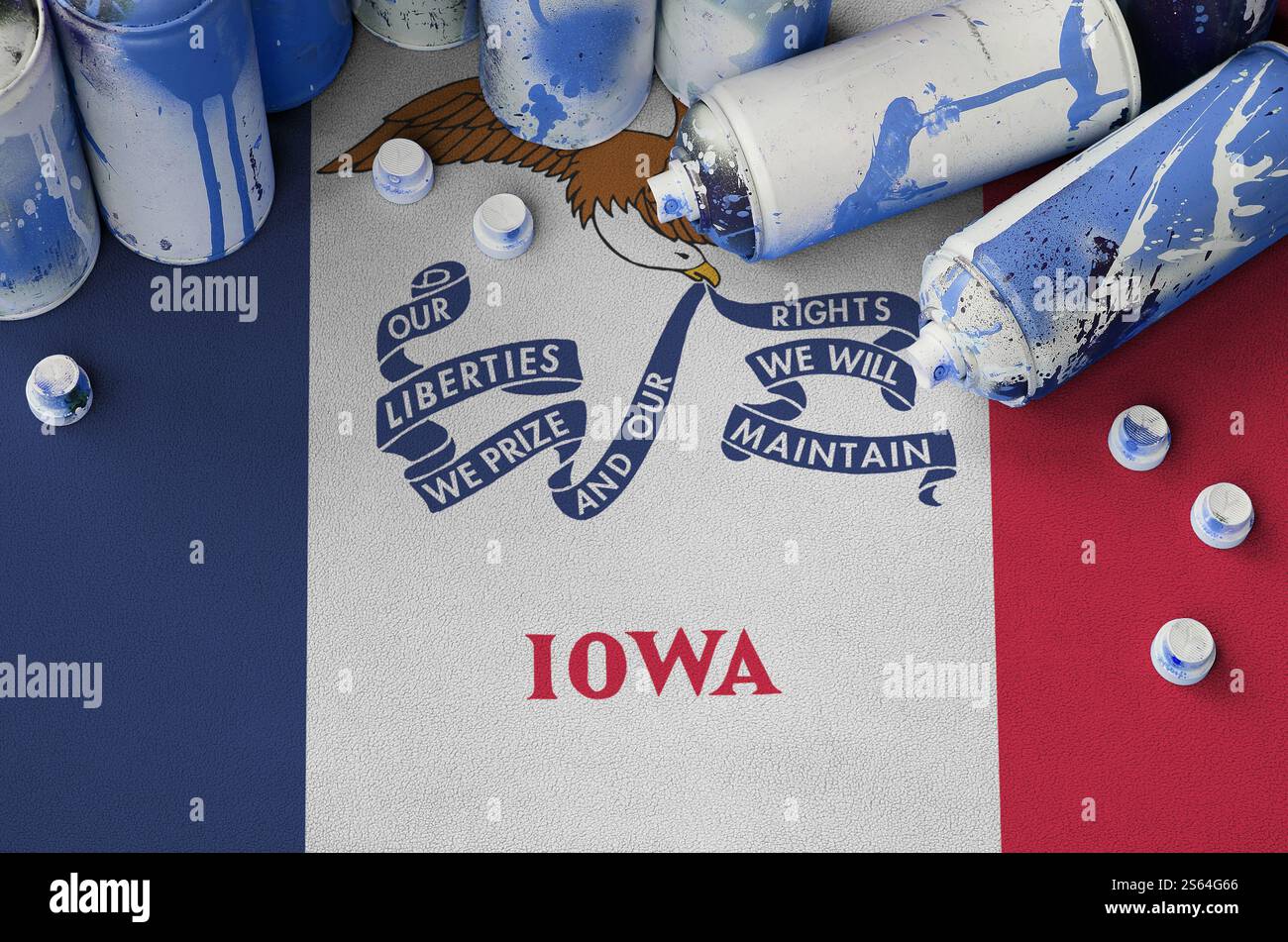 Iowa US state flag and few used aerosol spray cans for graffiti ...