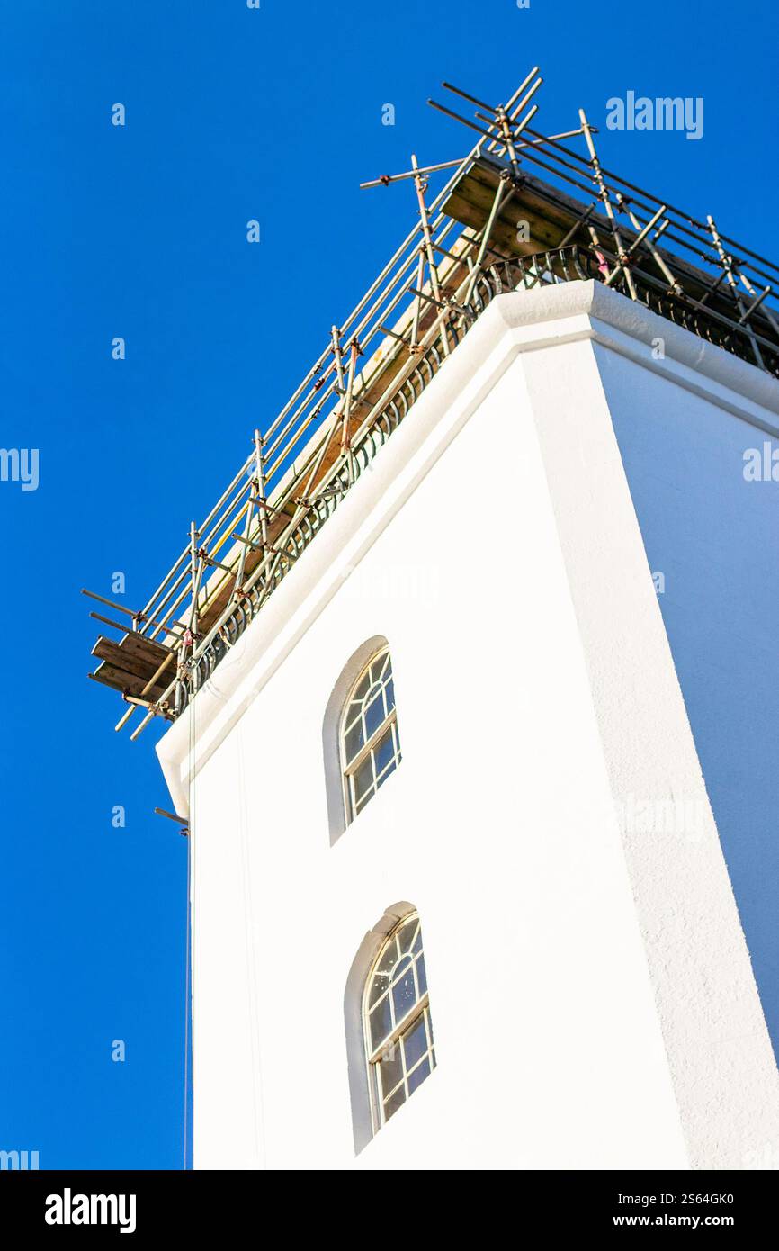 white fish quay lighthouse under renovation with scaffolding against a ...
